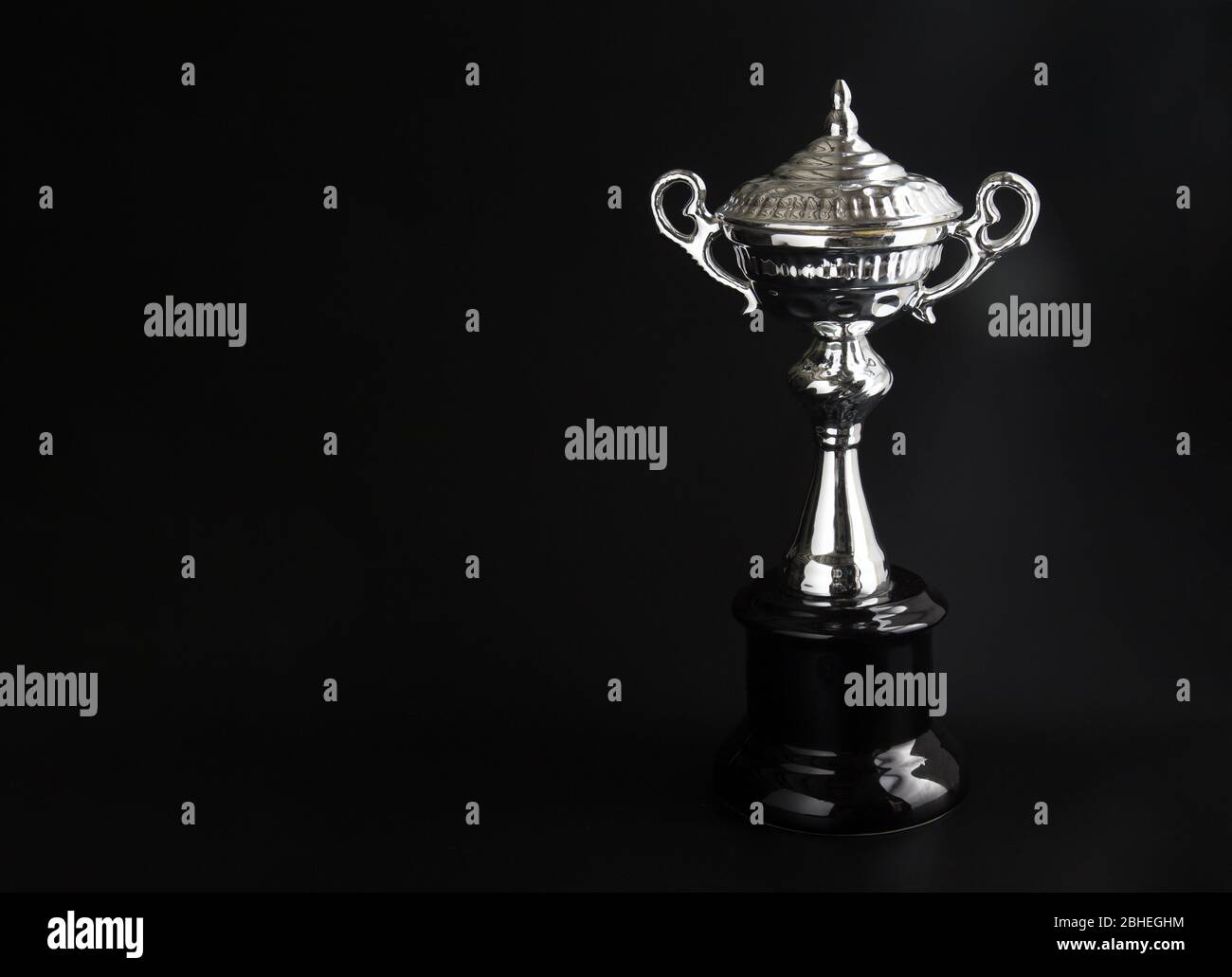 Silver trophy over black background. Winning awards with copy space for ...