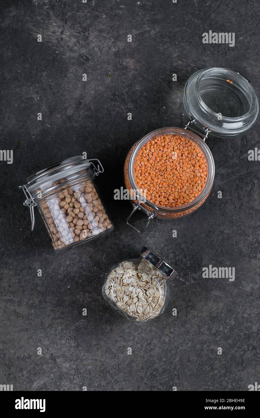 Various uncooked cereals, grains for healthy cooking in glass jars on ...