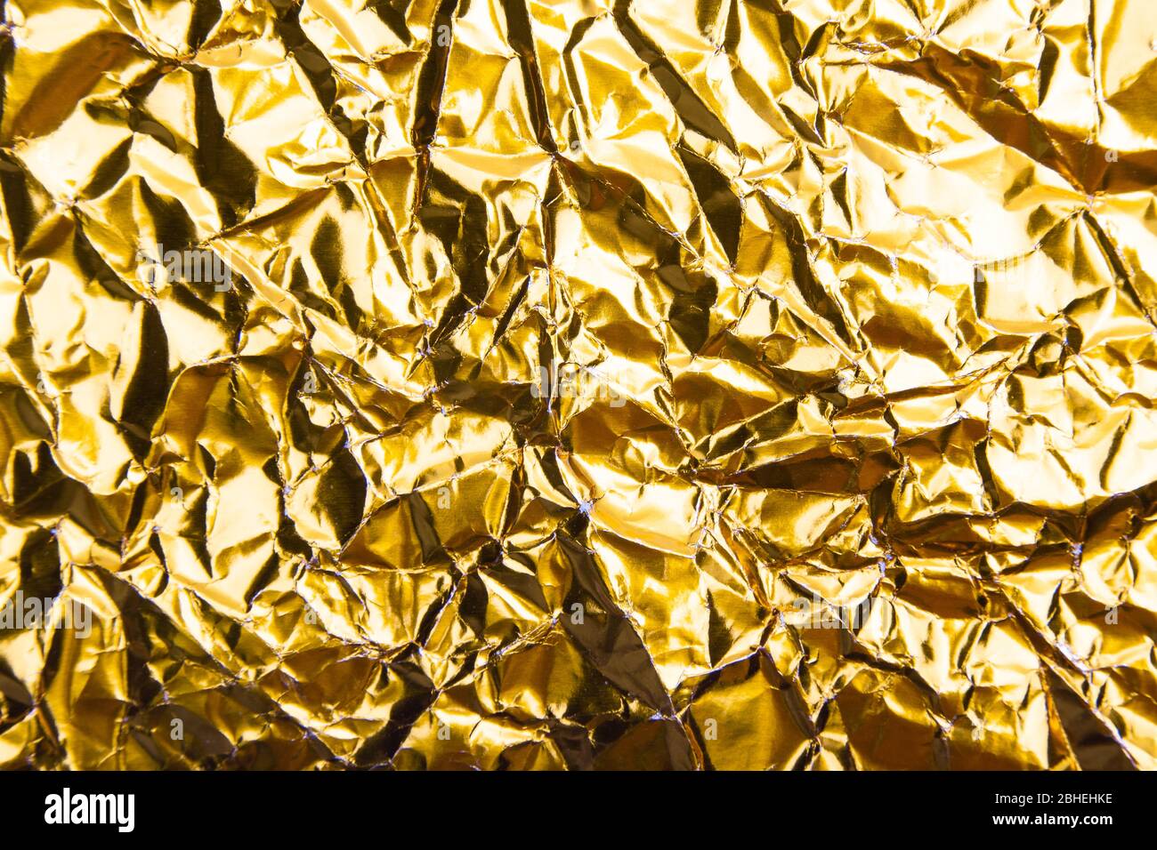 Gold crumpled foil paper texture background Stock Photo - Alamy