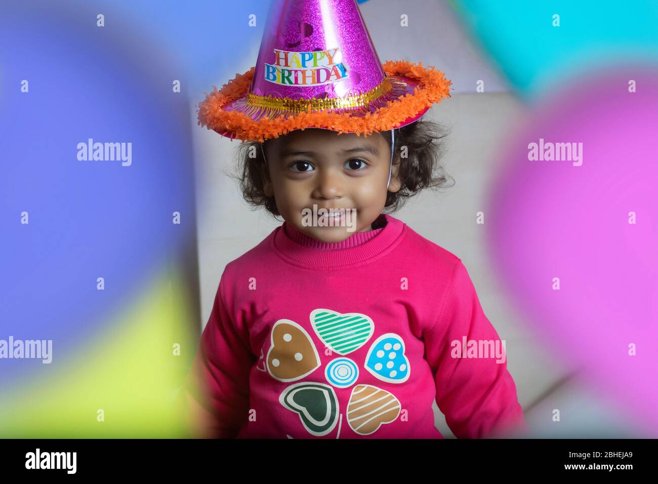 Young beautiful girl wearing birthday cap with a happy and cool smile ...