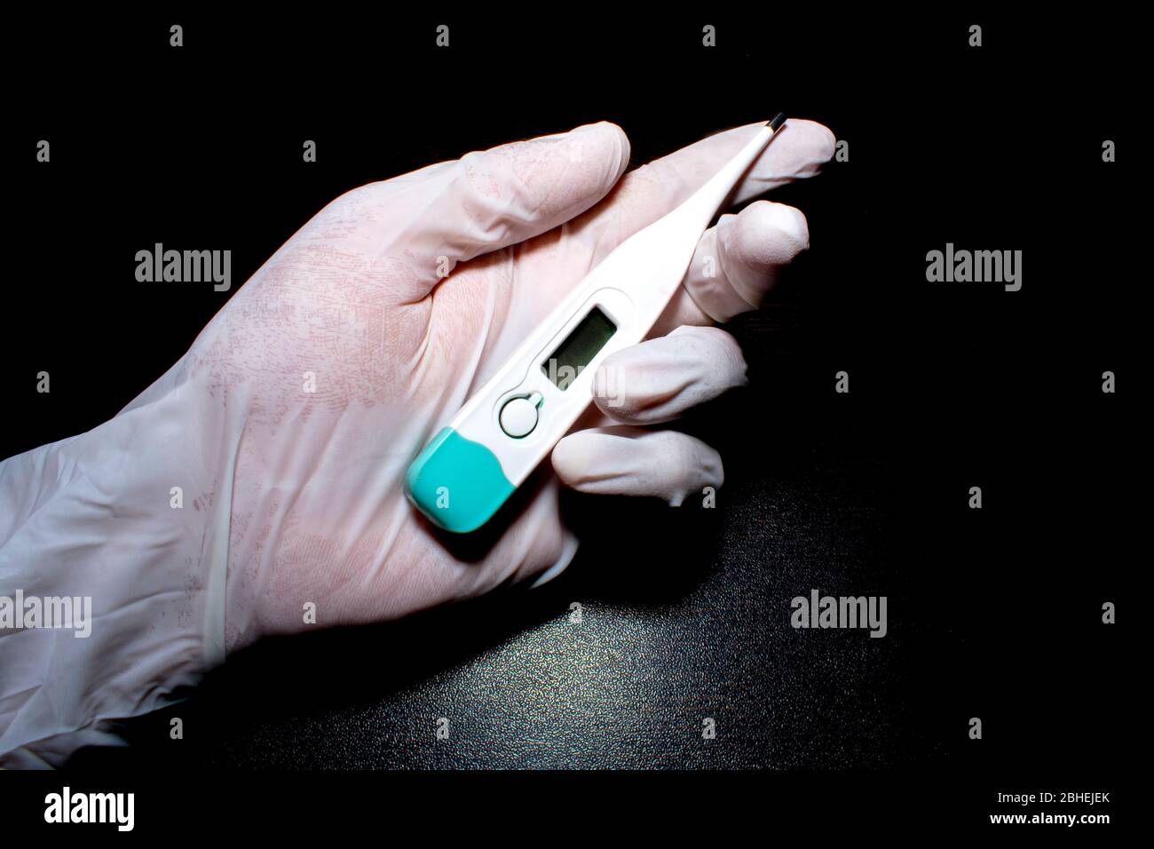 Digital digital thermometer in hand with gloves Stock Photo - Alamy