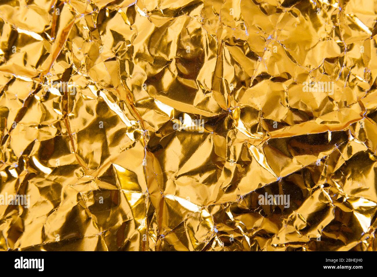 Gold crumpled foil paper texture background Stock Photo - Alamy