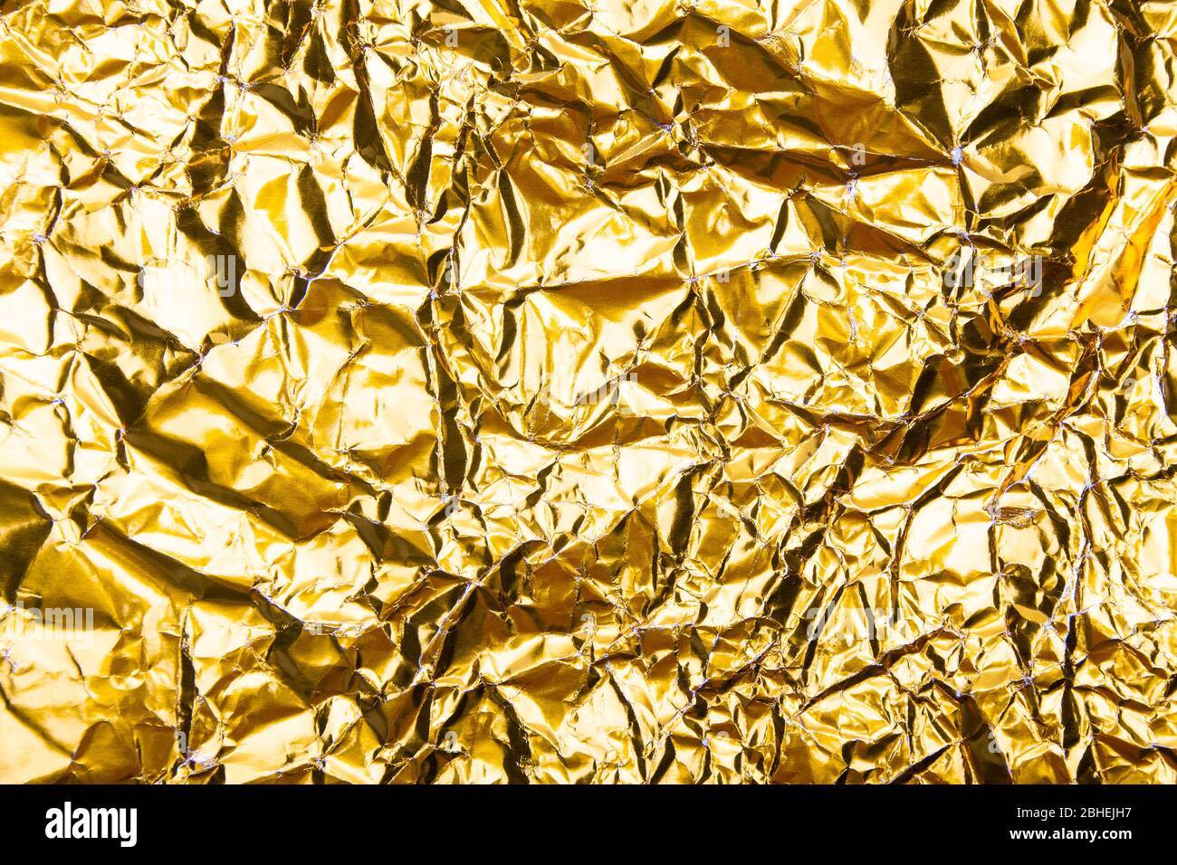 Gold crumpled foil paper texture background Stock Photo - Alamy