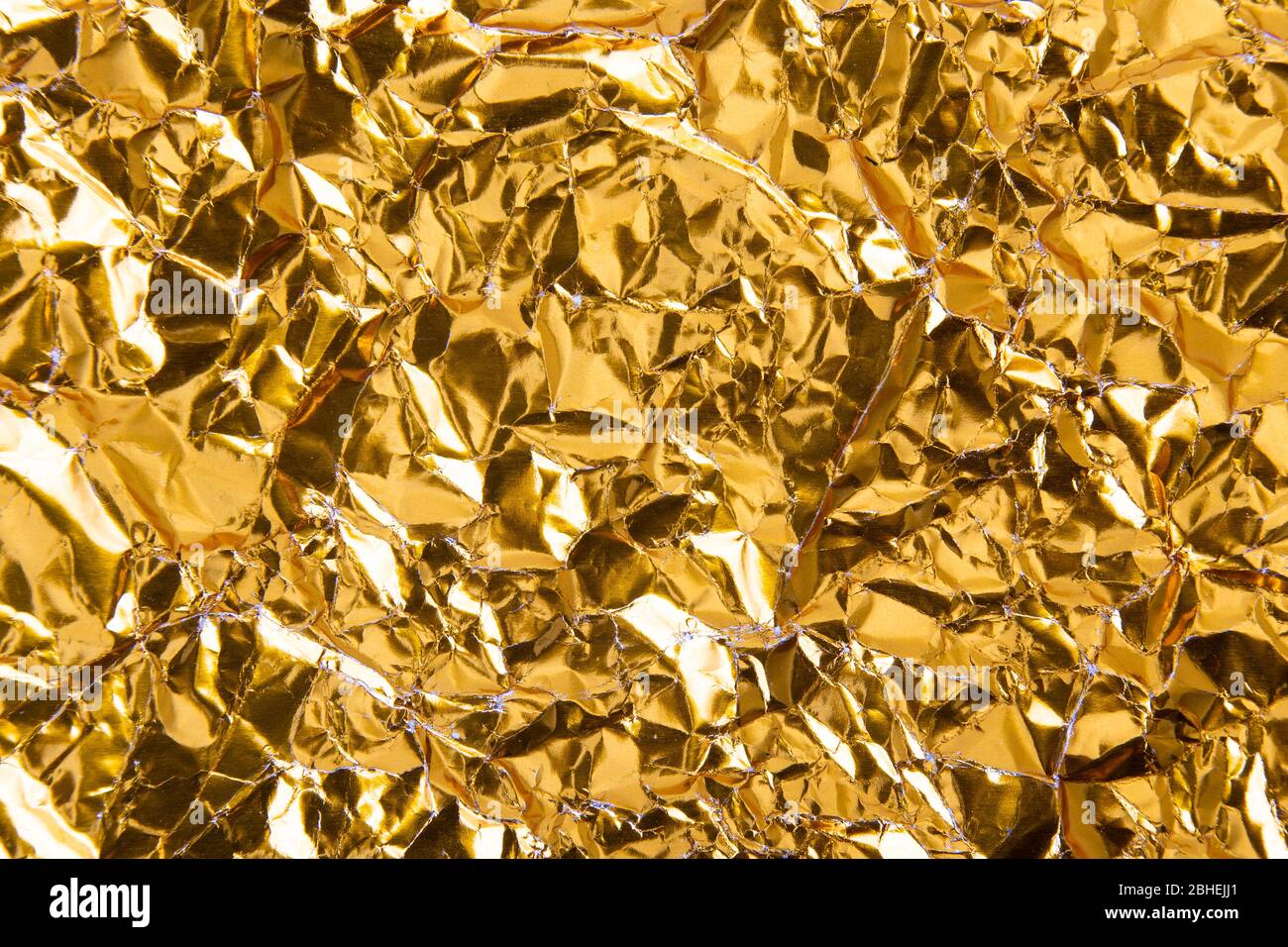 Gold crumpled foil paper texture background Stock Photo - Alamy