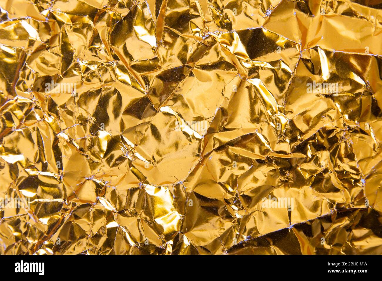Gold crumpled foil paper texture background Stock Photo - Alamy