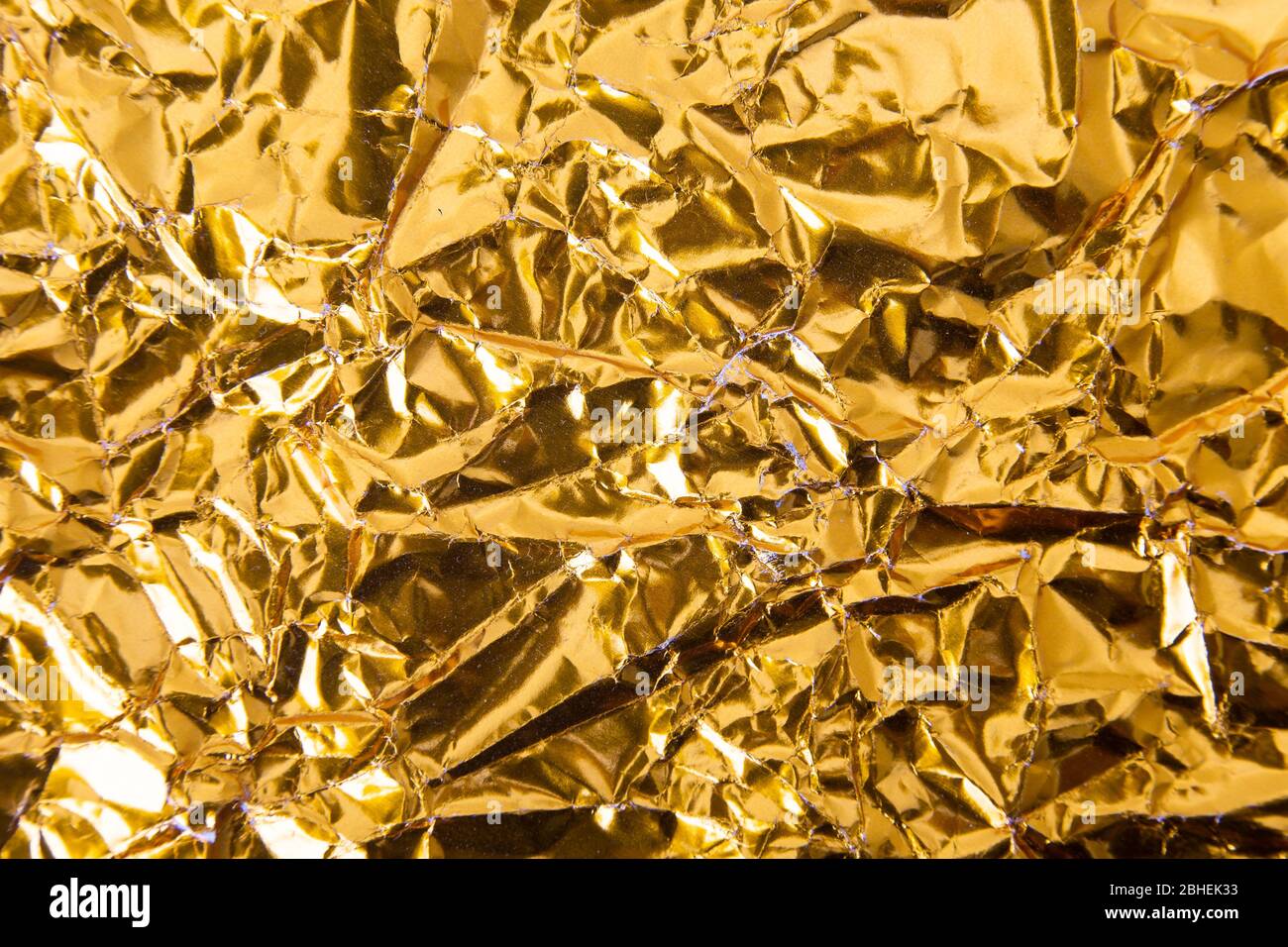 Gold crumpled foil paper texture background Stock Photo - Alamy