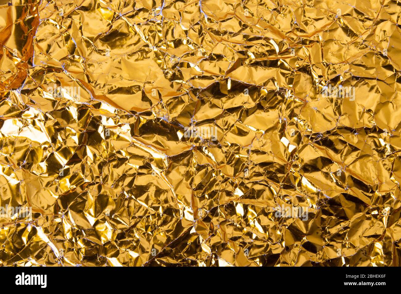 Gold crumpled foil paper texture background Stock Photo - Alamy
