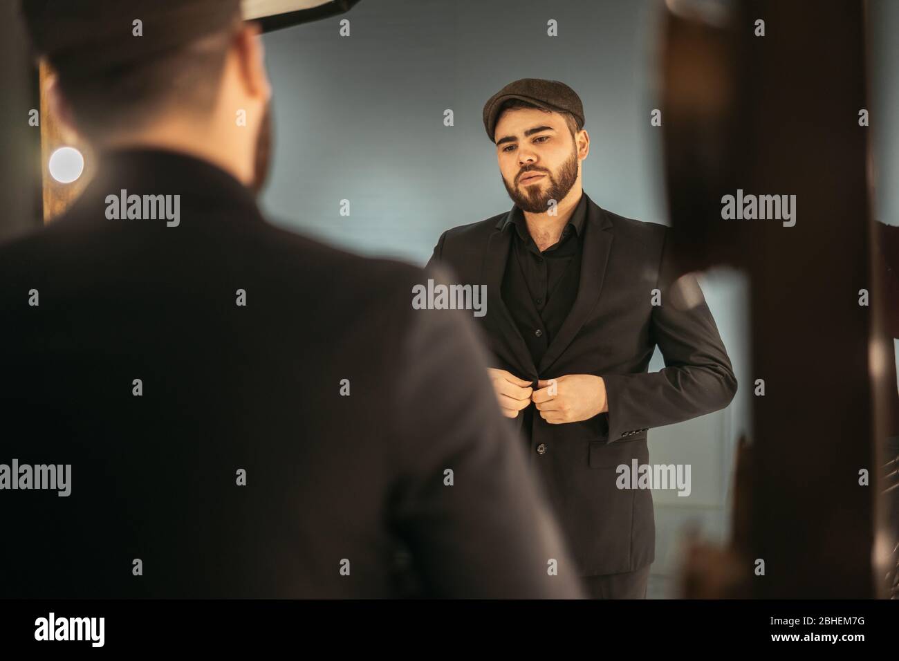 serious stylish attractive young man with beard dressing up with formal ...