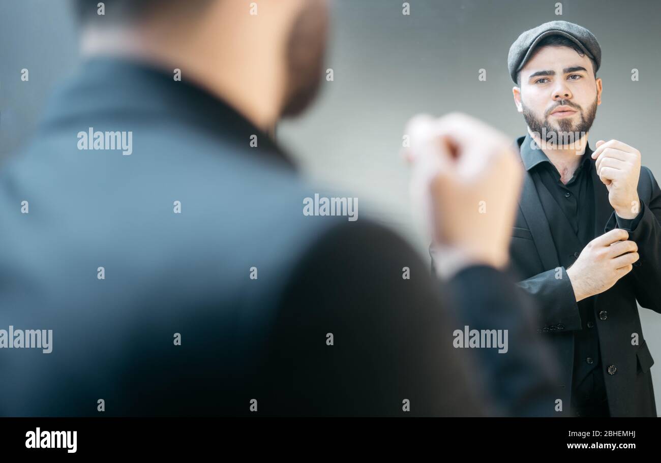 serious stylish attractive young man with beard dressing up with formal ...