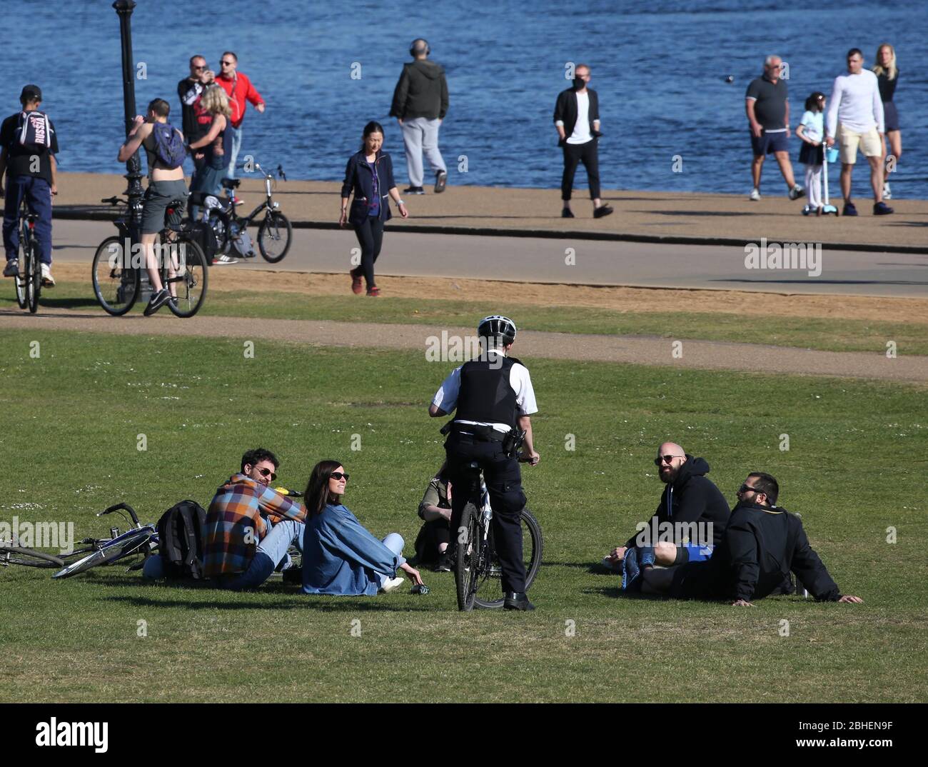 A police officer speaks to people relaxing by the Serpentine in Hyde ...