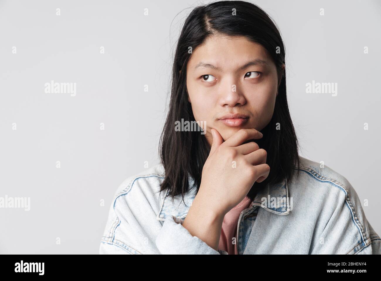 Image of thinking asian man posing and looking aside isolated over ...