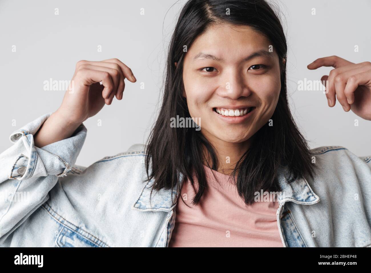 Image of pleased asian man smiling and throwing up hands isolated over ...