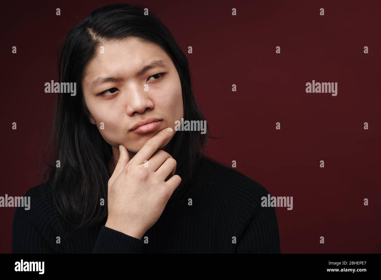 Image of thinking asian man posing and looking aside isolated over ...