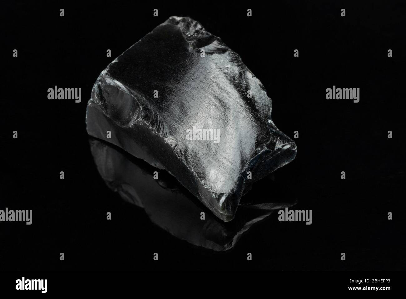 macro shot of an obsidian stone mineral specimen in it's raw form on a ...