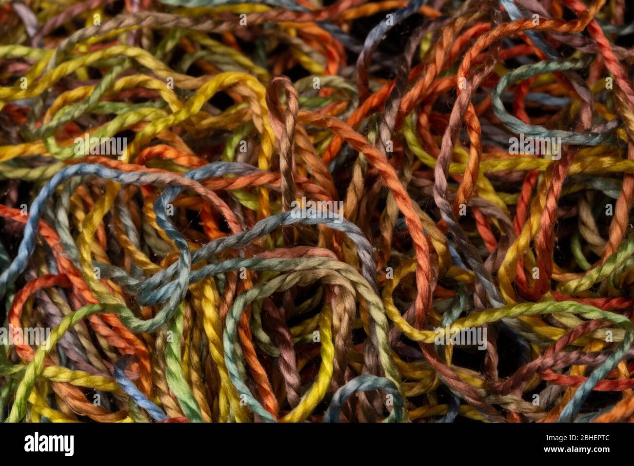 macro shot of variegated pure silk embroidery thread tangled in a pile ...