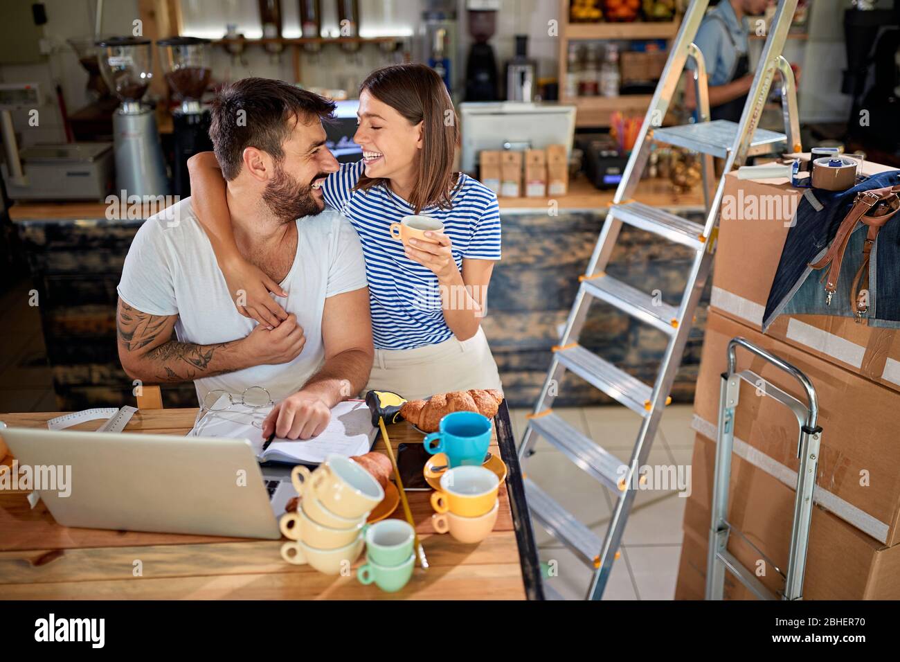 young attractive couple talking, hugging, holding hands, while planning ...