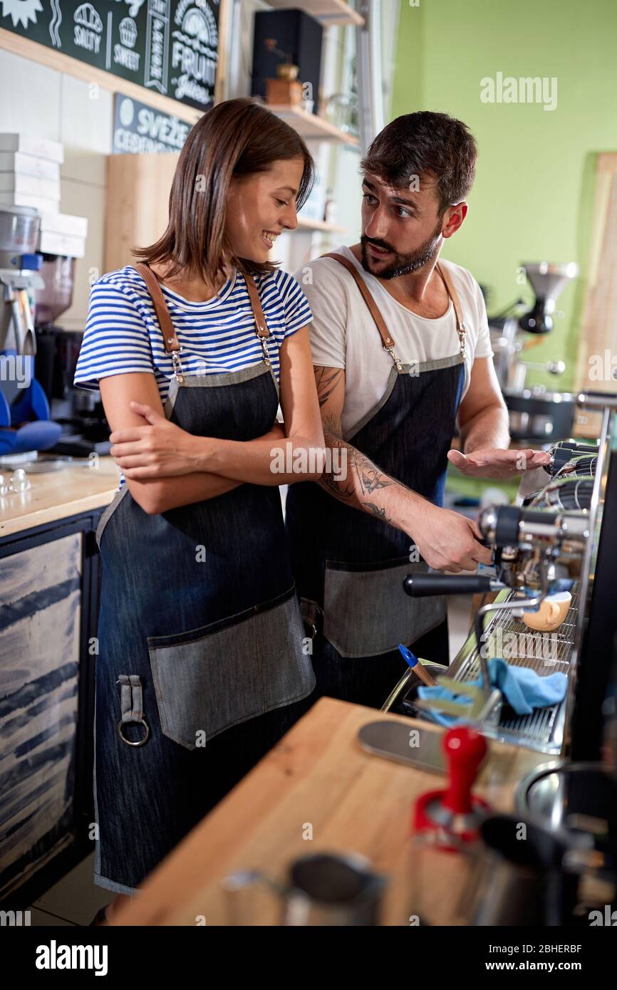 man showing how to make a good coffee to his new female colleague Stock ...