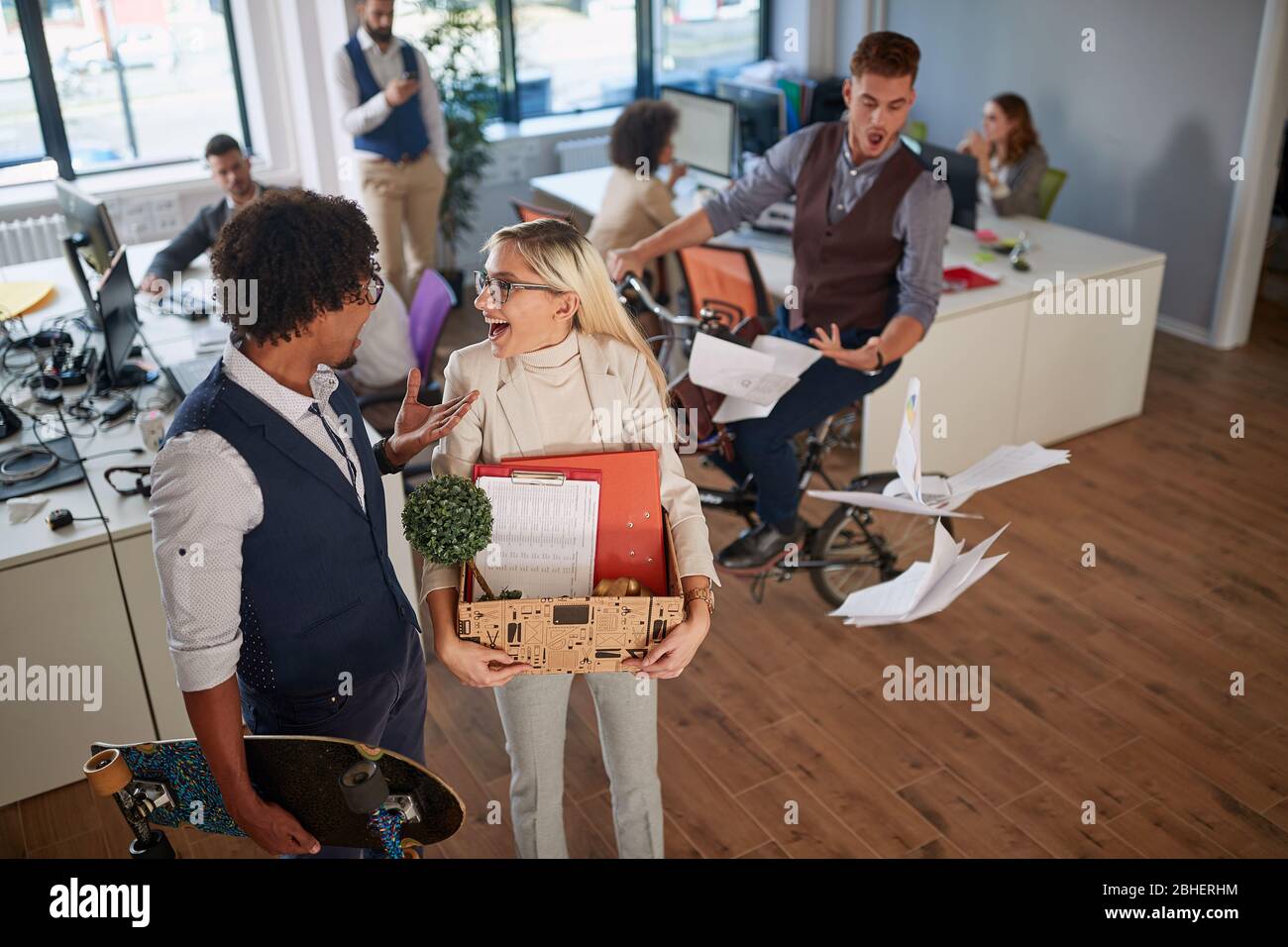 colleagues talking and laughing in modern open space office while ...