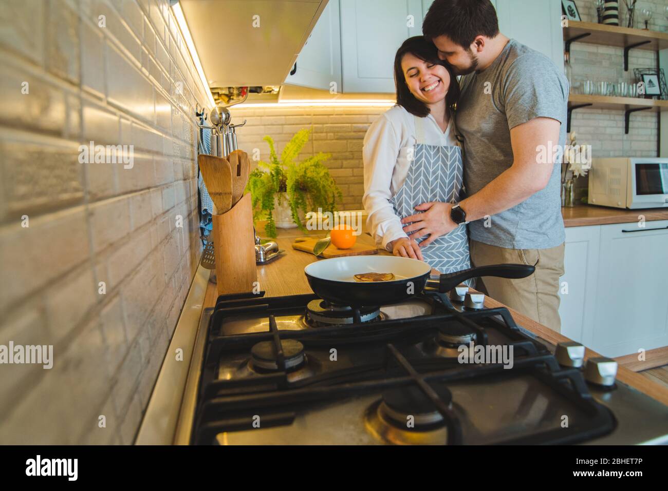 lovely couple hugging on the kitchen while cooking breakfast Stock ...