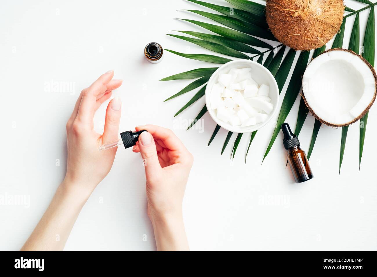 Female hands applying coconut oil for hand skin moisturizing. Flat lay ...