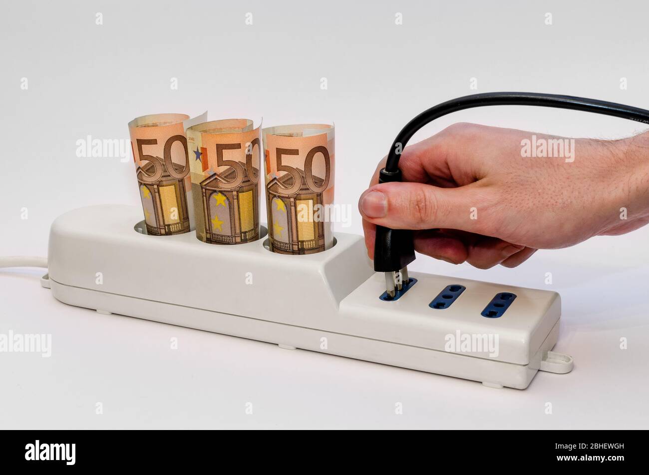 Power strip with money, white background and an hand holding a plug ...