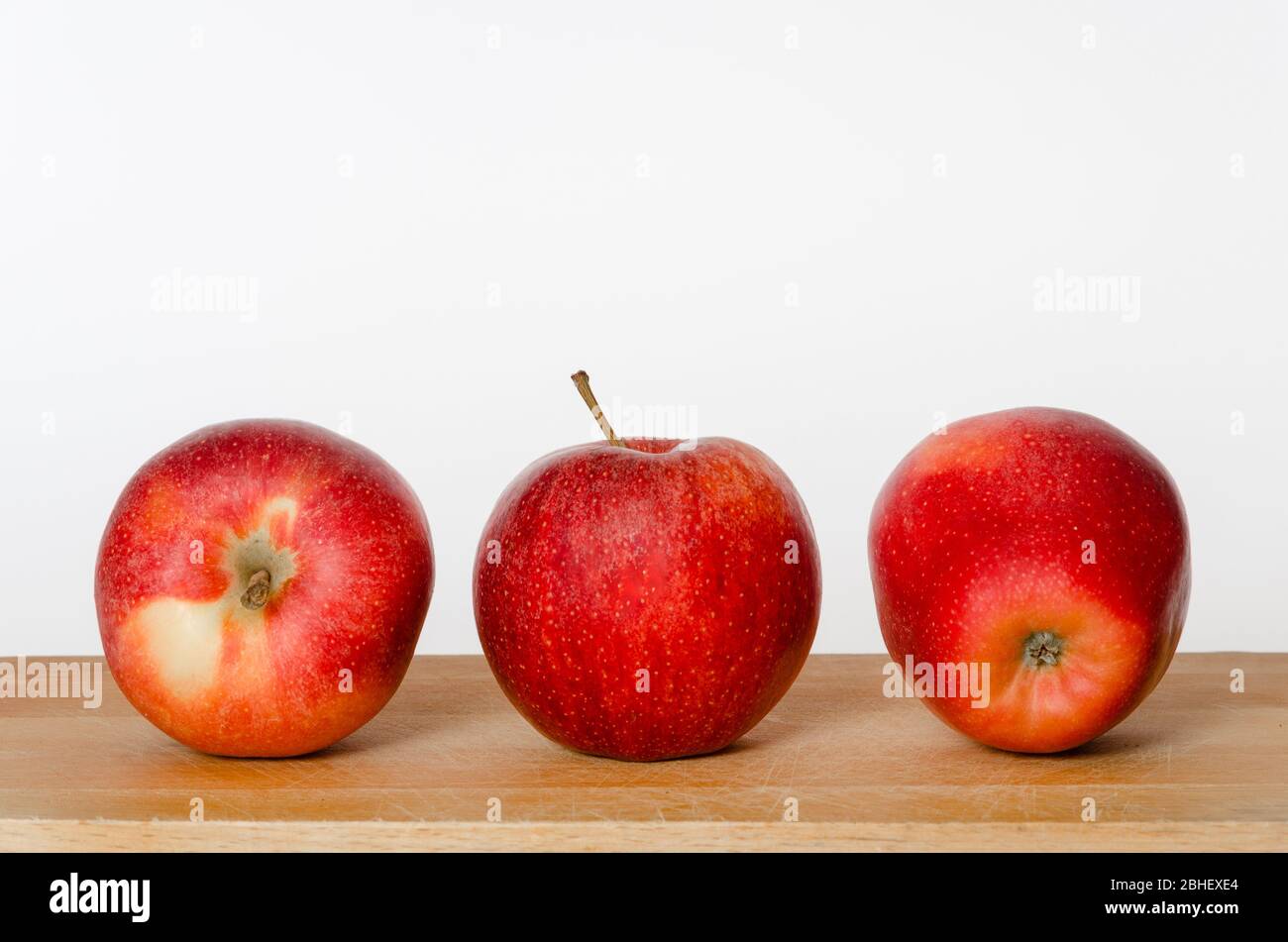 Front, rear and side look of tree apples in line on a chopping board ...