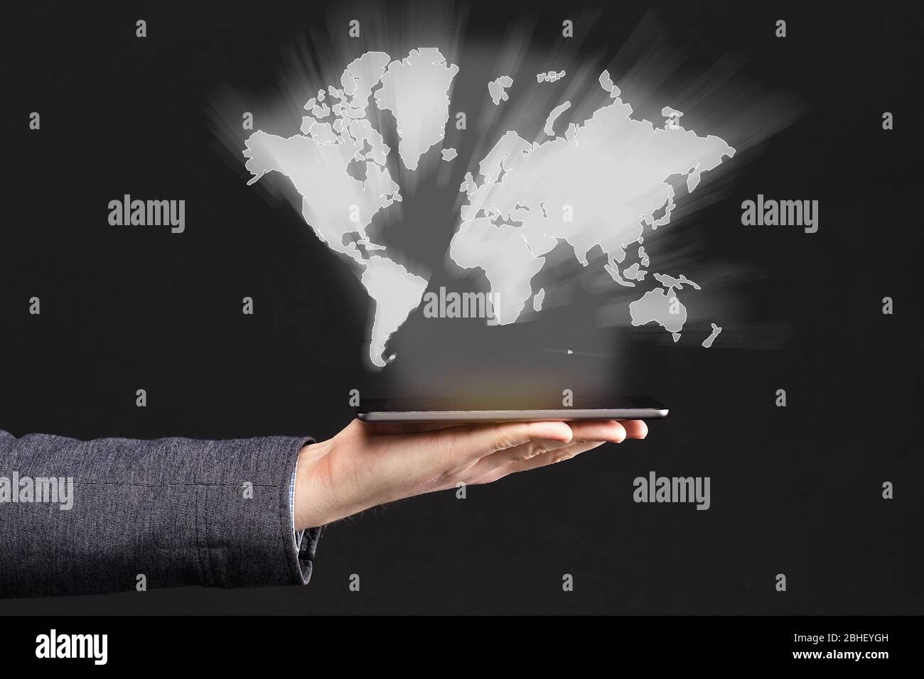 Business concept on a world map through a tablet that holds a hand ...