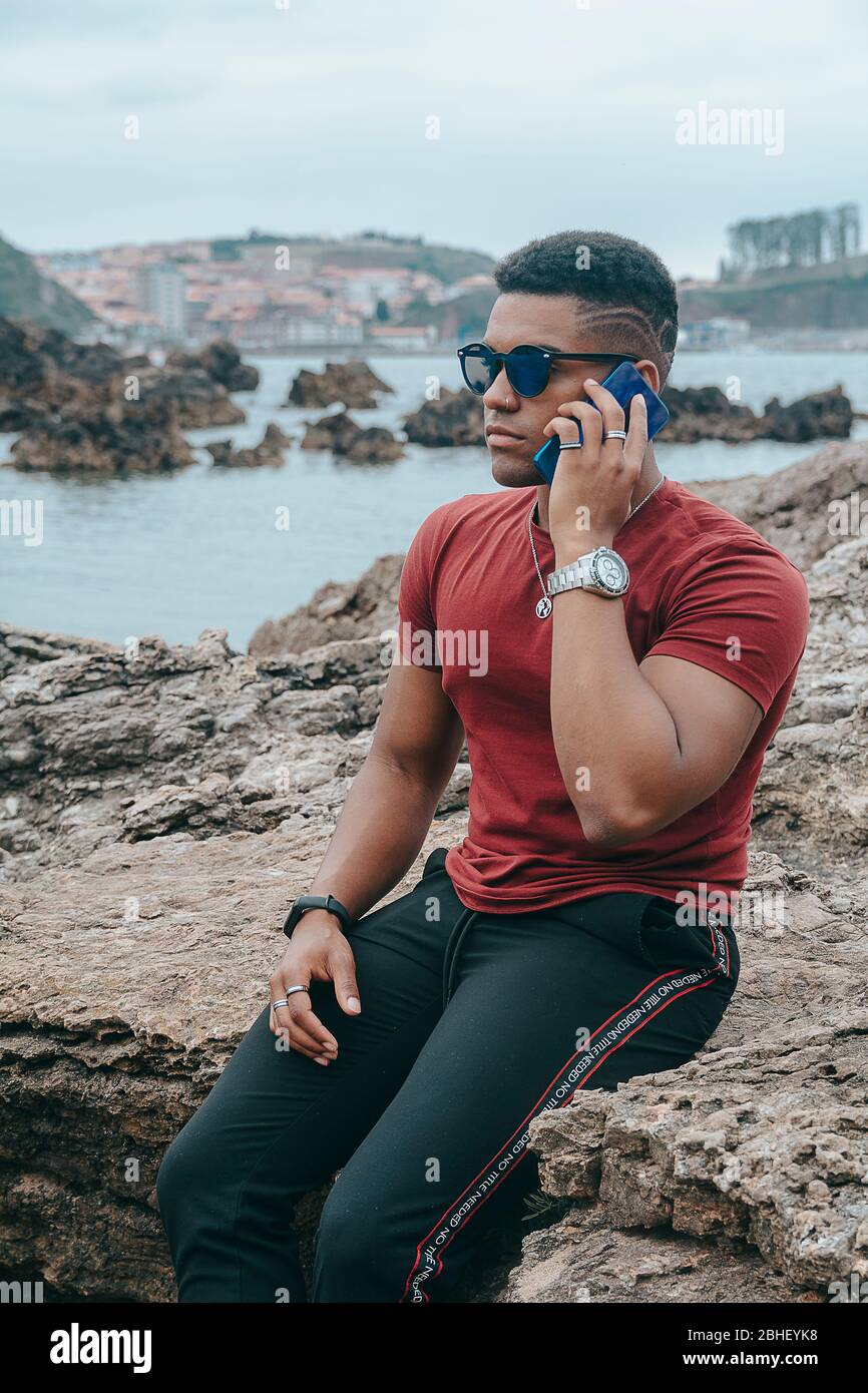 Beautiful shot of a young man with a cool hairstyle talking on his ...