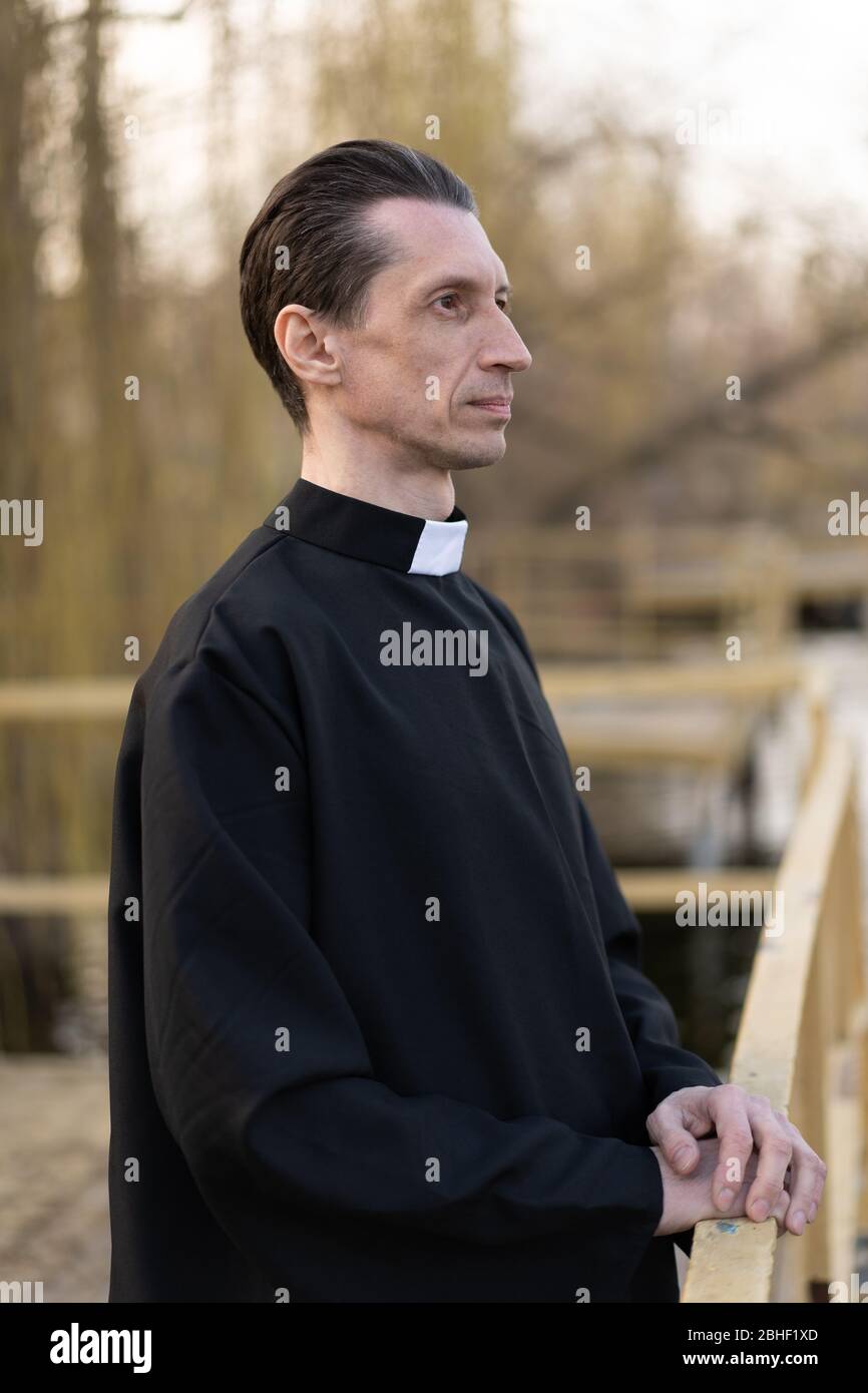 Portrait of handsome catholic priest or pastor with collar Standing ...