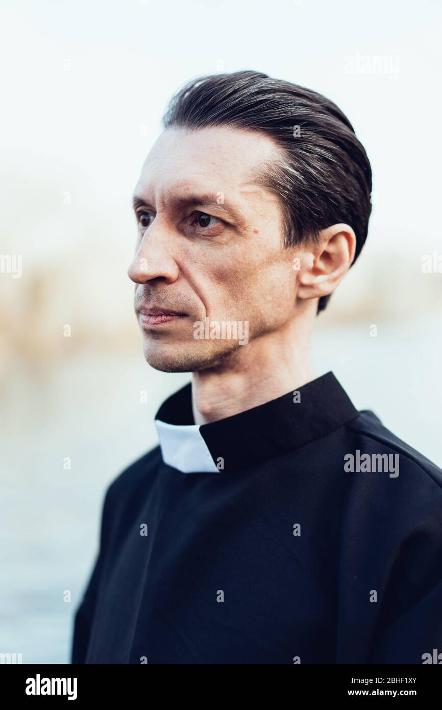 Portrait of handsome catholic priest or pastor with collar Standing ...
