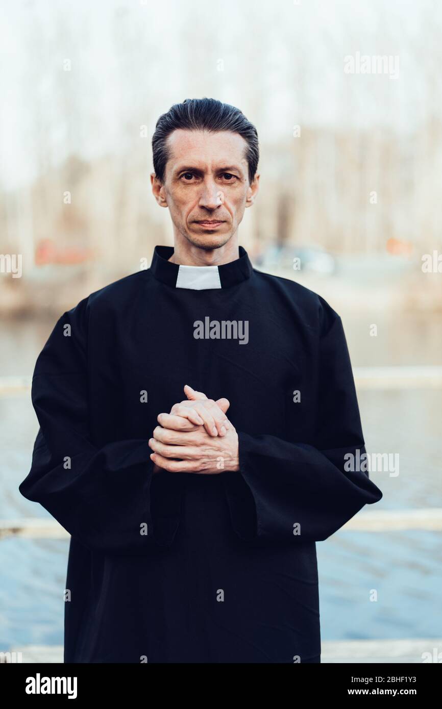 Portrait of handsome catholic priest or pastor with collar Standing ...