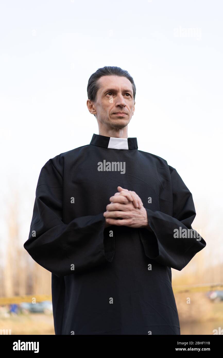 Portrait of handsome catholic priest or pastor with collar Standing ...