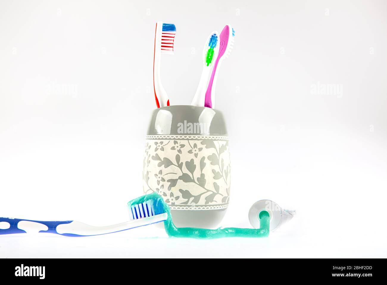 Green toothpaste and multi-colored toothbrushes stand in a special ...