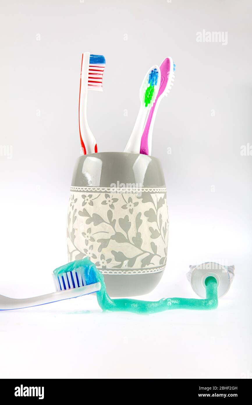 Green toothpaste and multi-colored toothbrushes stand in a special ...