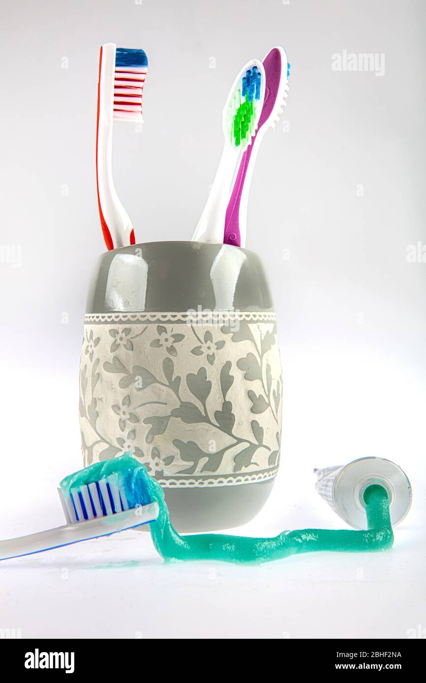 Green toothpaste and multi-colored toothbrushes stand in a special ...