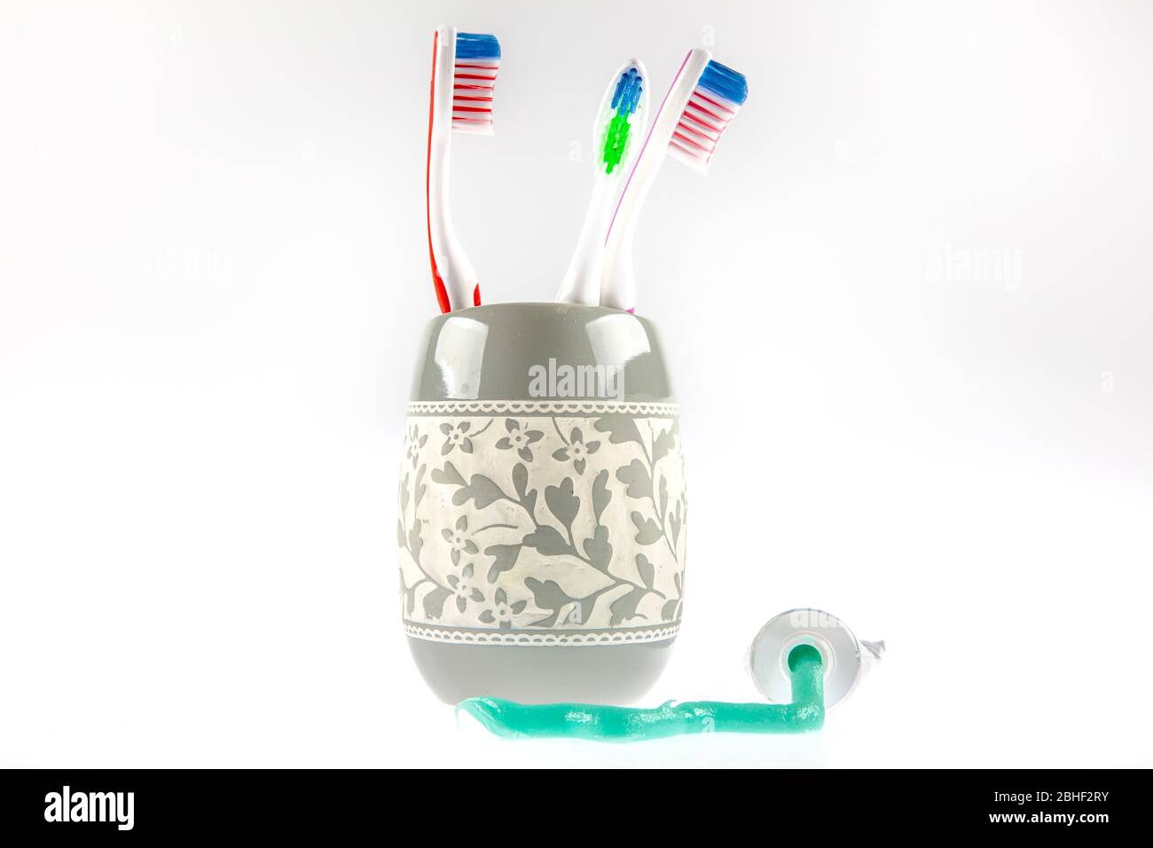 Green toothpaste and multi-colored toothbrushes stand in a special ...