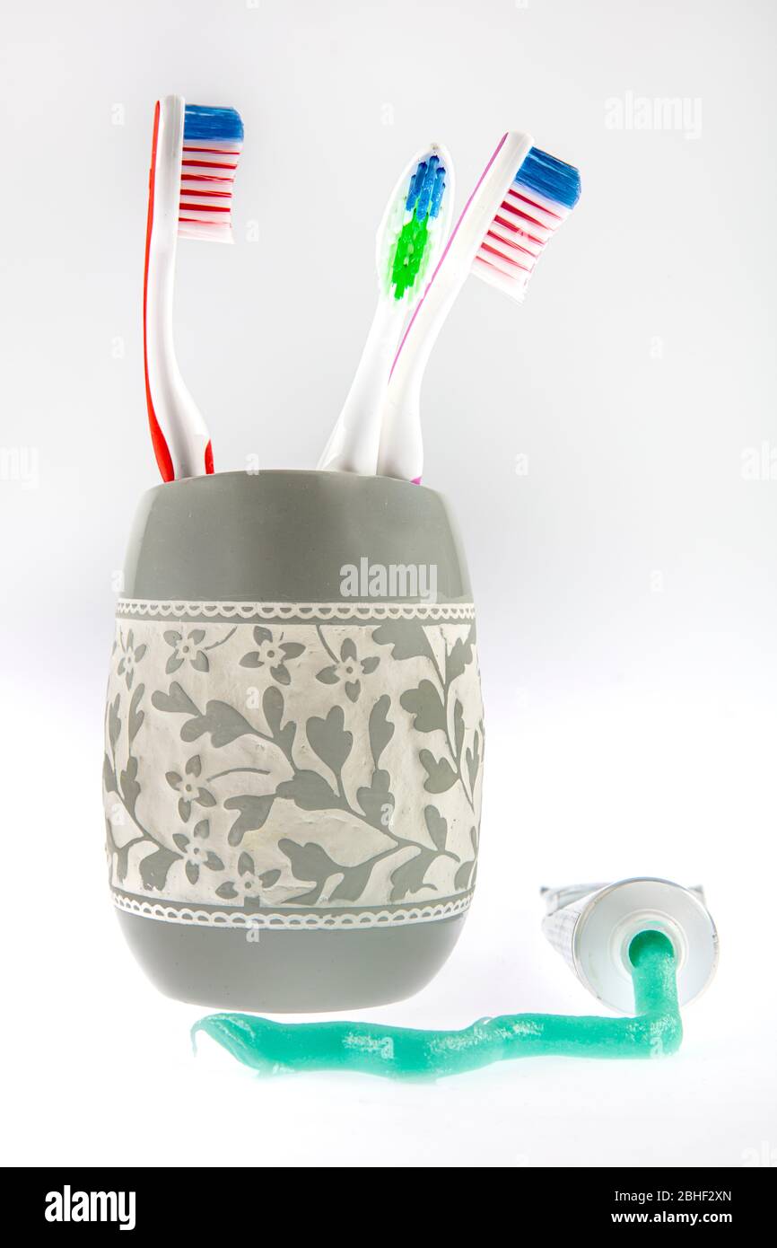 Green toothpaste and multi-colored toothbrushes stand in a special ...