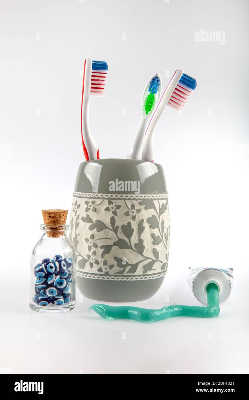 Green toothpaste and multi-colored toothbrushes stand in a special ...