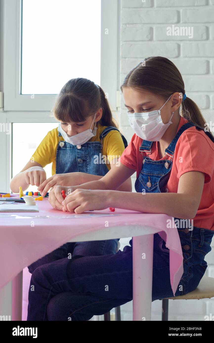 Two sisters in medical masks play board games Stock Photo - Alamy