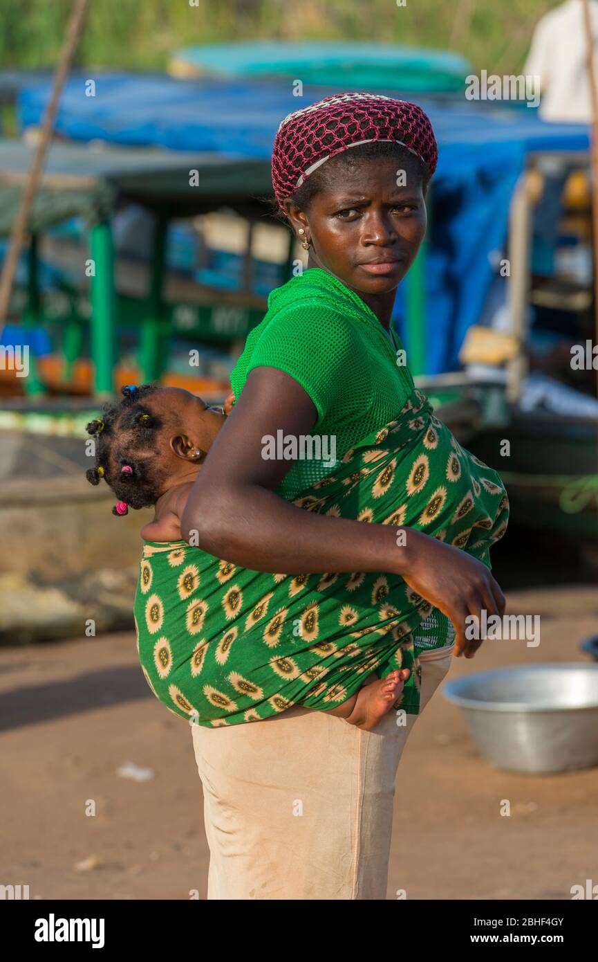 Mother carrying baby in a back sling at Lake Nokoue near Cotonou, Benin ...