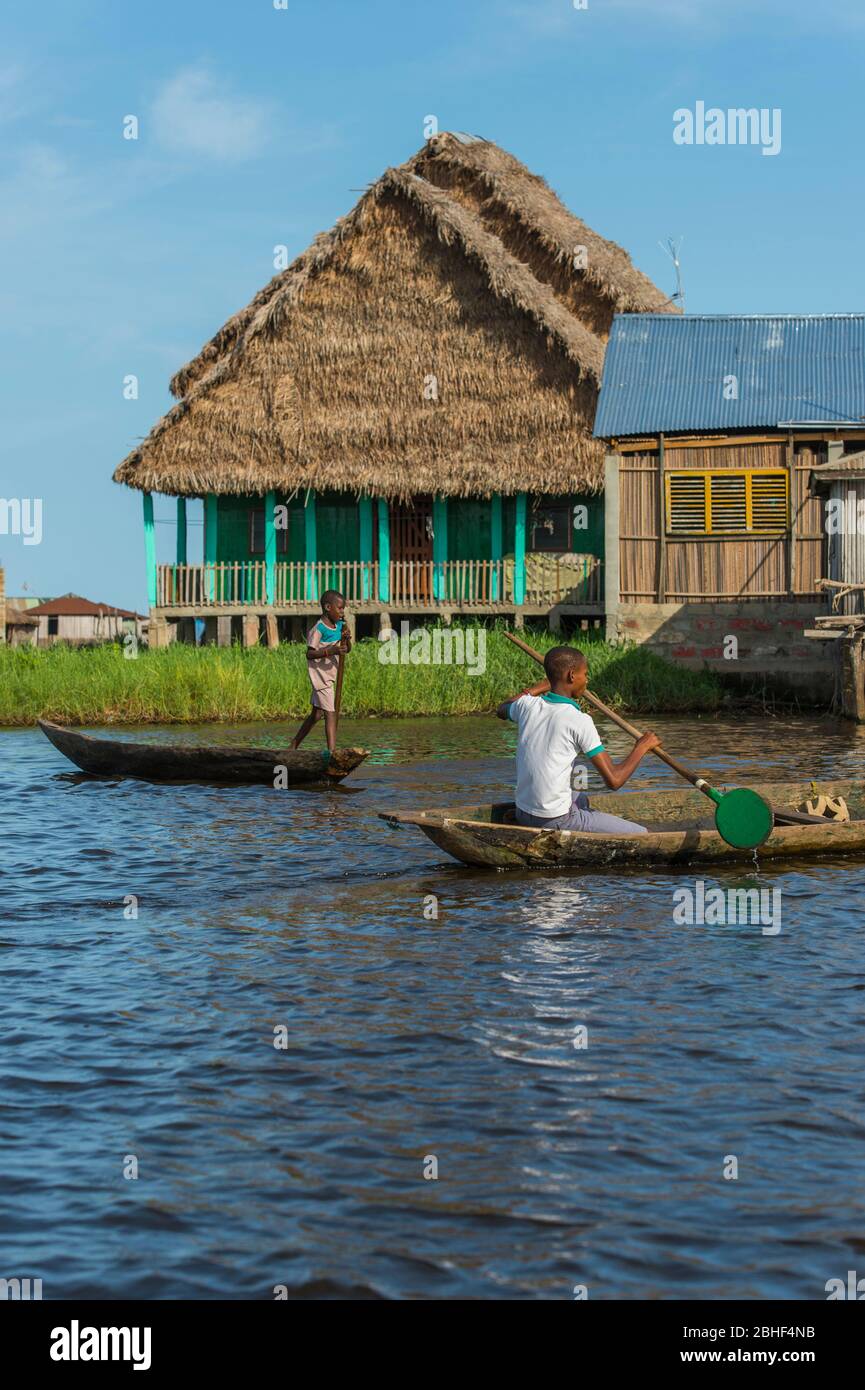 Ganvie village scene with people paddling boats, is a unique village ...