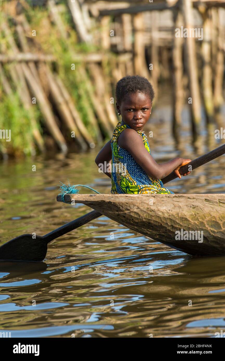 Ganvie village scene with girl paddling boat, is a unique village built ...