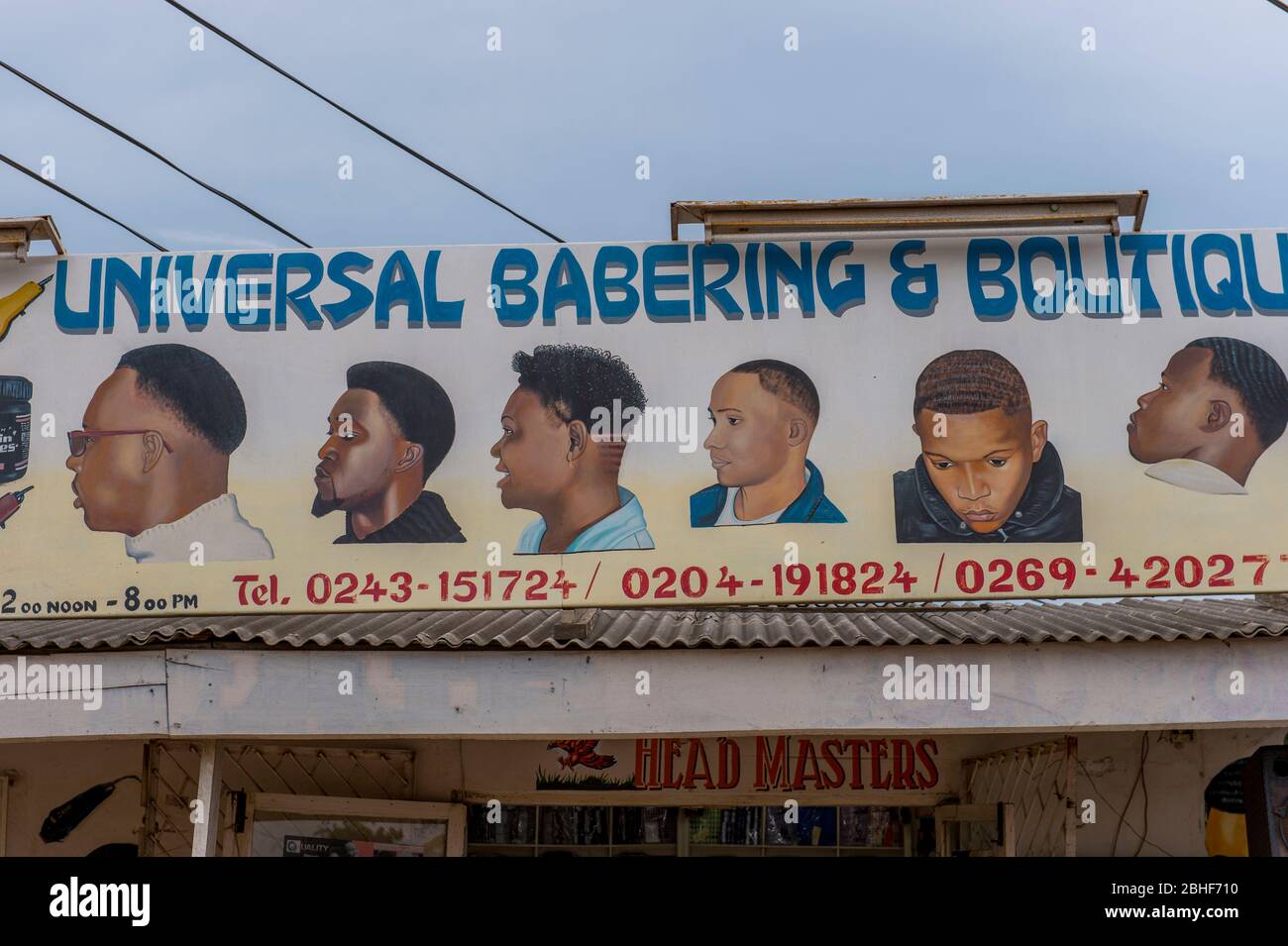 Street scene with advertising sign for a barber shop in Accra the ...