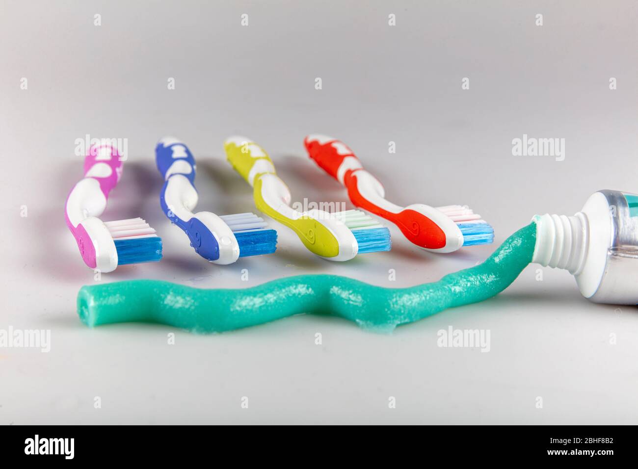 Toothbrushes and green toothpaste on white background Stock Photo - Alamy