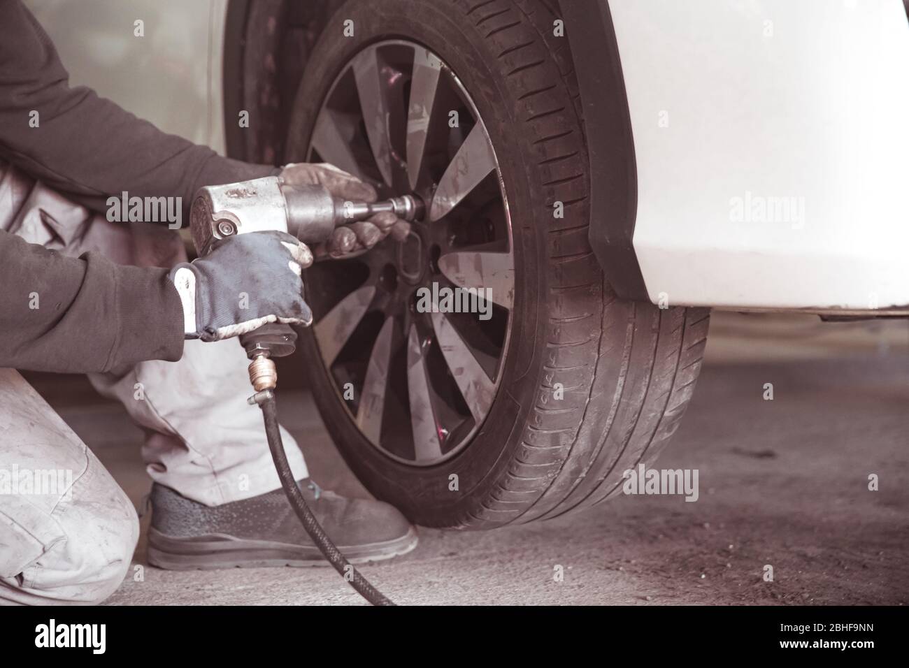 screwing the wheel to the car using a pneumatic screwdriver ...