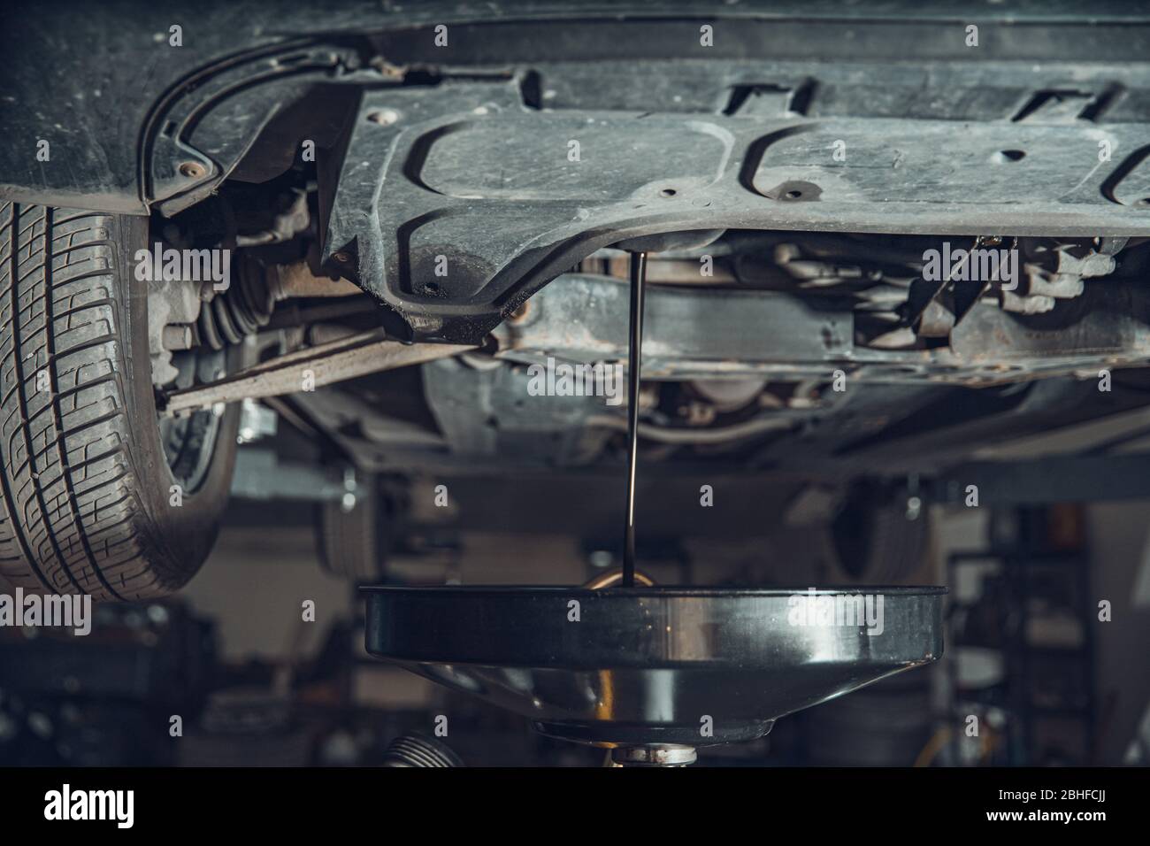 Draining used oil from a car engine in a car repair shop Stock Photo ...