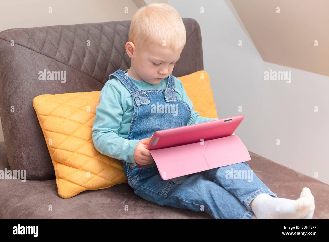 Cute toddler boy holding digital tablet and watching cartoons. Kids and ...