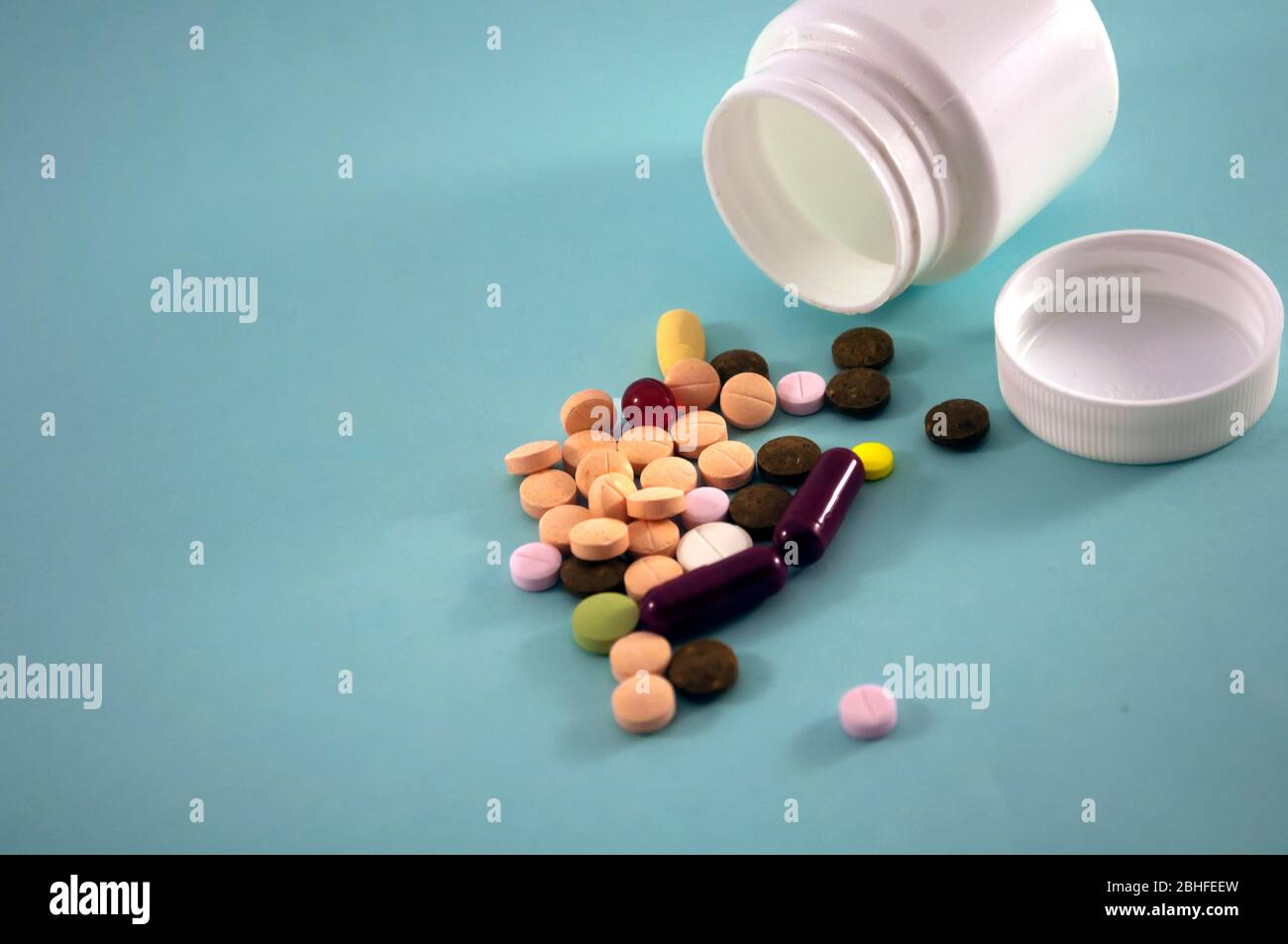 Mix pills and bottle for pills on a blue background. Pills scattered ...