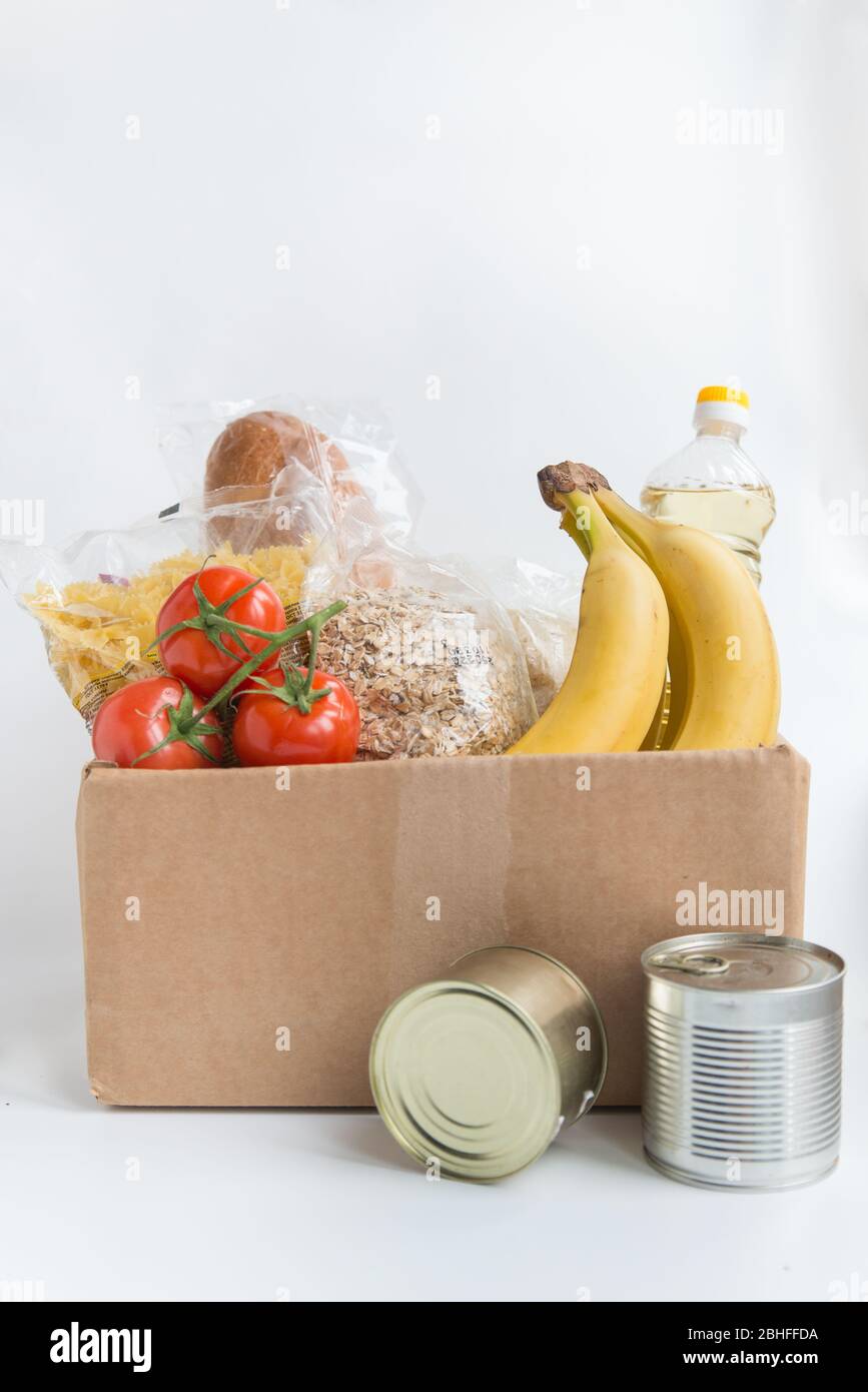 Various canned food, pasta, rice, oil, bananas and raw cereal grains on ...