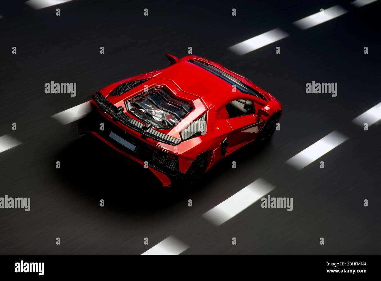 Top and rear view of a red sports car on an asphalt background with ...